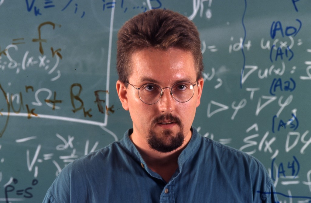 Professor Michael Holst, standing in front of a chalkboard. — Calisphere