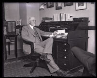 Dr. Robert L. Kelly sitting at his desk, 1920-1939 — Calisphere
