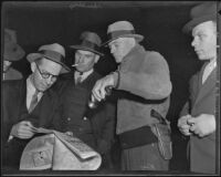 Three men, including Bill Spaulding and James D. Key, read a newspaper ...