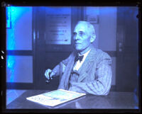 Printer Senaca Beach seated at a desk, Los Angeles, 926-1929 — Calisphere