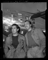 Actors Tyrone Power and Cesar Romero beside Power's plane on return ...