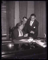 Minnie Kennedy signs a document with Guy Edward Hudson and Barney ...