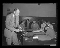 Roger Otis demonstrates a recording device at the trial of Jack Santo ...