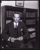David H. Clark seated in an office, Los Angeles, 1931 — Calisphere