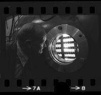 Physicist Kenneth R. Mackenzie looking into plasma chamber at UCLA ...