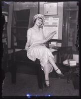 Actress Symona Boniface sitting on the edge of a table holding a ...