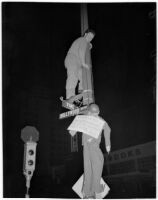 Man removes a dummy hanging from the Hollywood and Vine street signs ...
