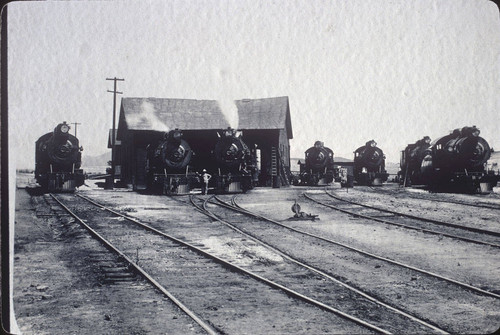 The ""Round House"" and steam locomotives on railroad tracks in ...