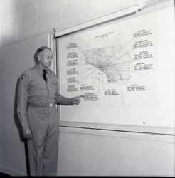 Two officers at Fort MacArthur discussing map of domestic deployments ...