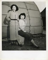 Two young women posing at military base — Calisphere