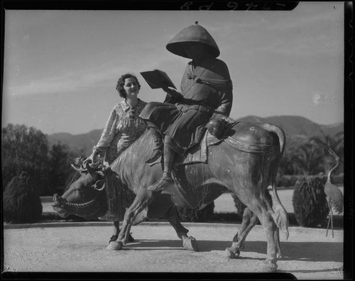 Woman with statue of Tenjin reading on the back of an ox, Bernheimer ...