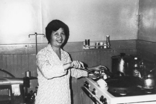 Bick Ng, cooking in the kitchen — Calisphere