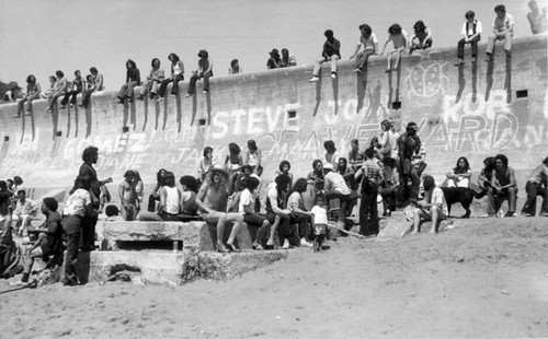 [Group of people hanging out by the wall at Ocean Beach] — Calisphere