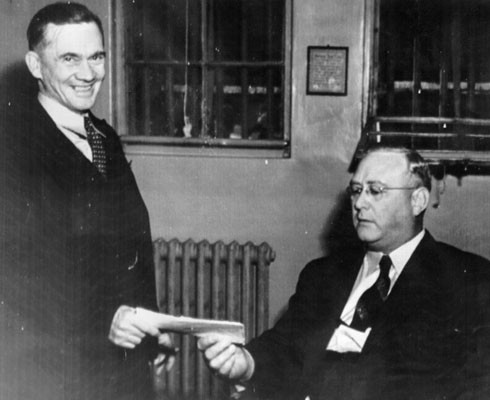 [Warden Clyde Plummer shown returning envelope containing valuables to ...