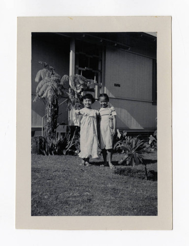 Two girls standing outside of house in Honolulu — Calisphere
