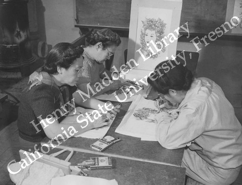 Three students doing steamed crayon work for tablecloths and wall ...