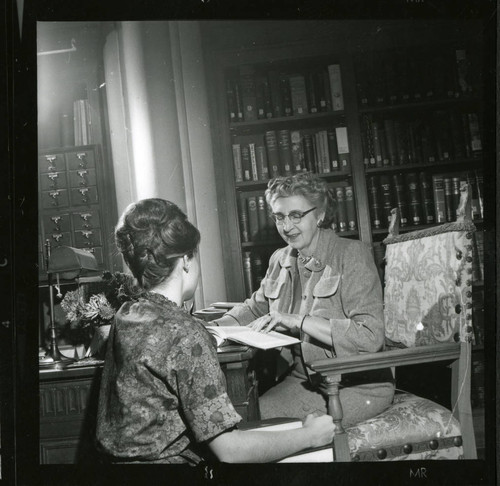 Dorothy Drake reads to a student at her desk in Denison Library ...