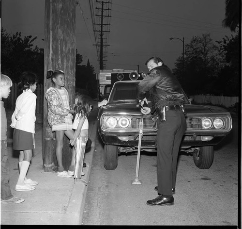 Compton police officer changing a tire, Compton, California, 1971 ...
