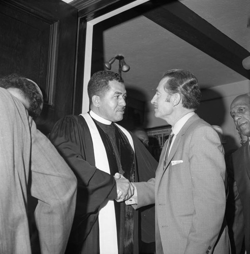 Pastor shaking hands in the church hallway, Los Angeles, 1969 — Calisphere