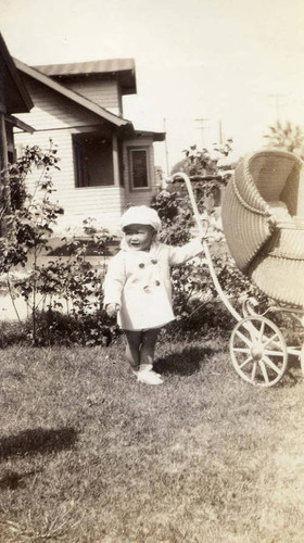 One year old Ronald Siu holding onto his baby carriage — Calisphere