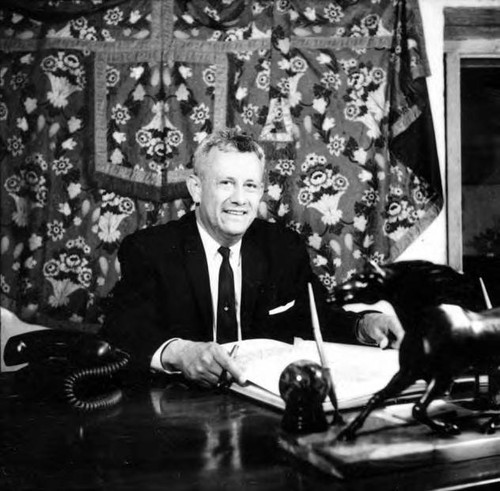 Mario Valadez sitting at a desk — Calisphere