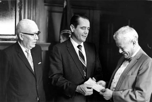Mario Valadez receiving a check from Reinecke — Calisphere