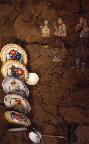 Photographs and dishes hanging from a wall, San Basilio de Palenque ...