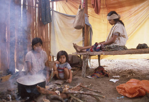 Mayan women and child near a pot of boiling water, Chajul, ca. 1983 ...