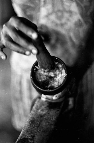 A woman mixes food in a small bowl while cooking, San Basilio de ...