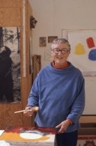 Ann O'Hanlon smiling at camera while painting in studio, 1977 — Calisphere