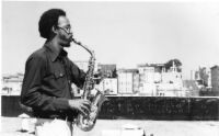 Lewis Jordan playing saxophone on a rooftop, 1978 [descriptive ...
