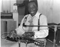 Reverend Lonnie Farris performing at church on a slide guitar, 1977 ...