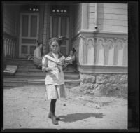 Elizabeth West stands in front of a building, while Mary West and ...