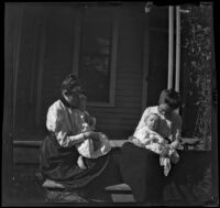 Grace Butterfield and Claude Bishop sit on a porch holding children on ...