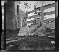 Marion McIntyre (probably) and her sister, Lucille, sit by a fence with ...