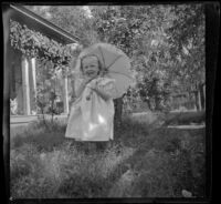 Lucille McIntyre holds a parasol in stands in the front yard of the ...