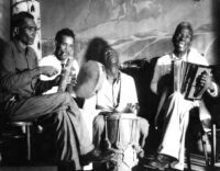 Photo of four musicians each playing different instruments — Calisphere