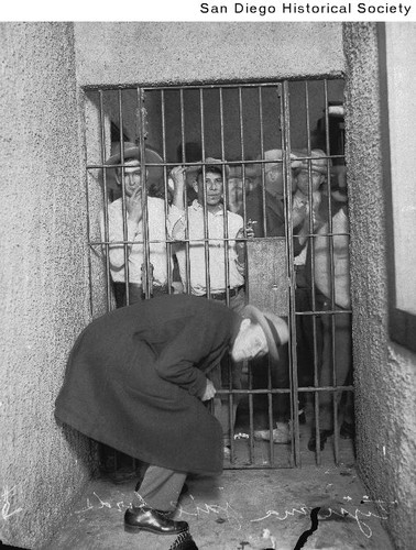 Group of men behind bars of a jail in Tijuana, Mexico — Calisphere