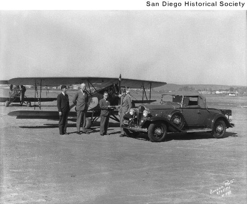 Charles Lindbergh standing with three men near an automobile and an ...