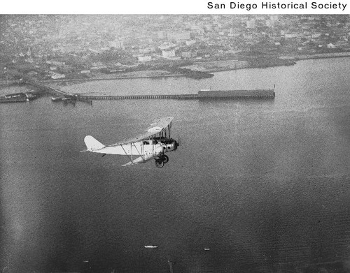 A Ryan airplane flying over San Diego Harbor — Calisphere