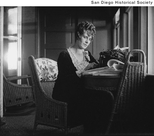 Aimee Semple McPherson seated at a desk in the Hotel del Coronado ...