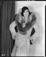 Peggy Hamilton modeling an ermine coat with red fox collar and a cloche ...