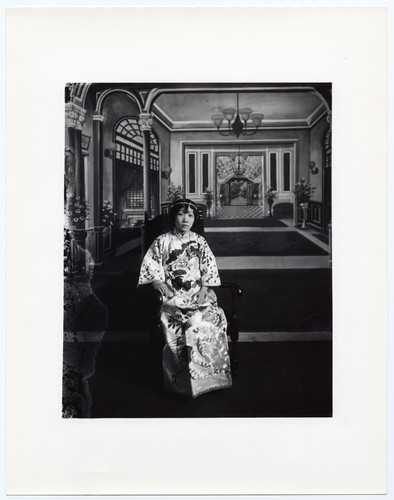 Portrait of an actress in a modern gi pao seated in a mansion interiror ...