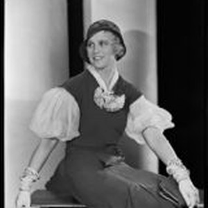 Peggy Hamilton modeling a fitted dress, a hat and embroidered gloves ...
