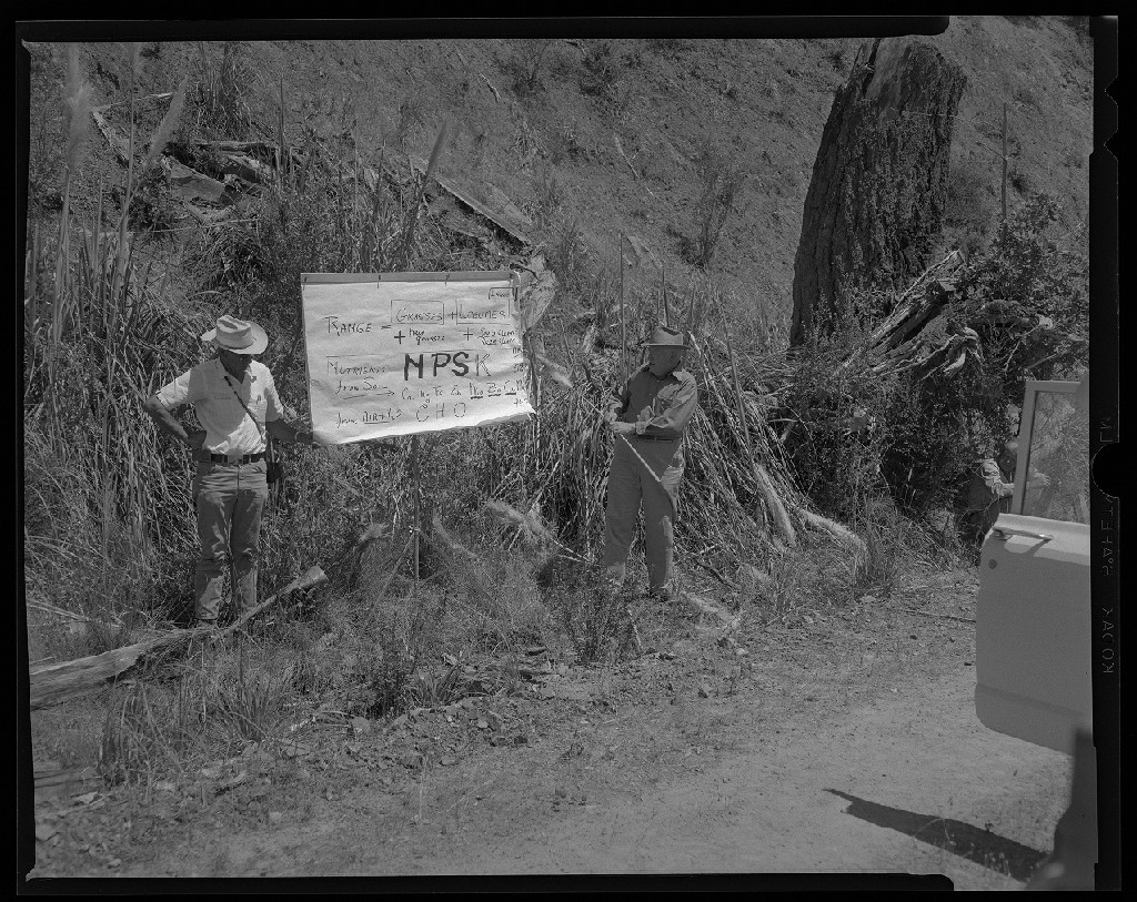 [Two men reading off board] — Calisphere