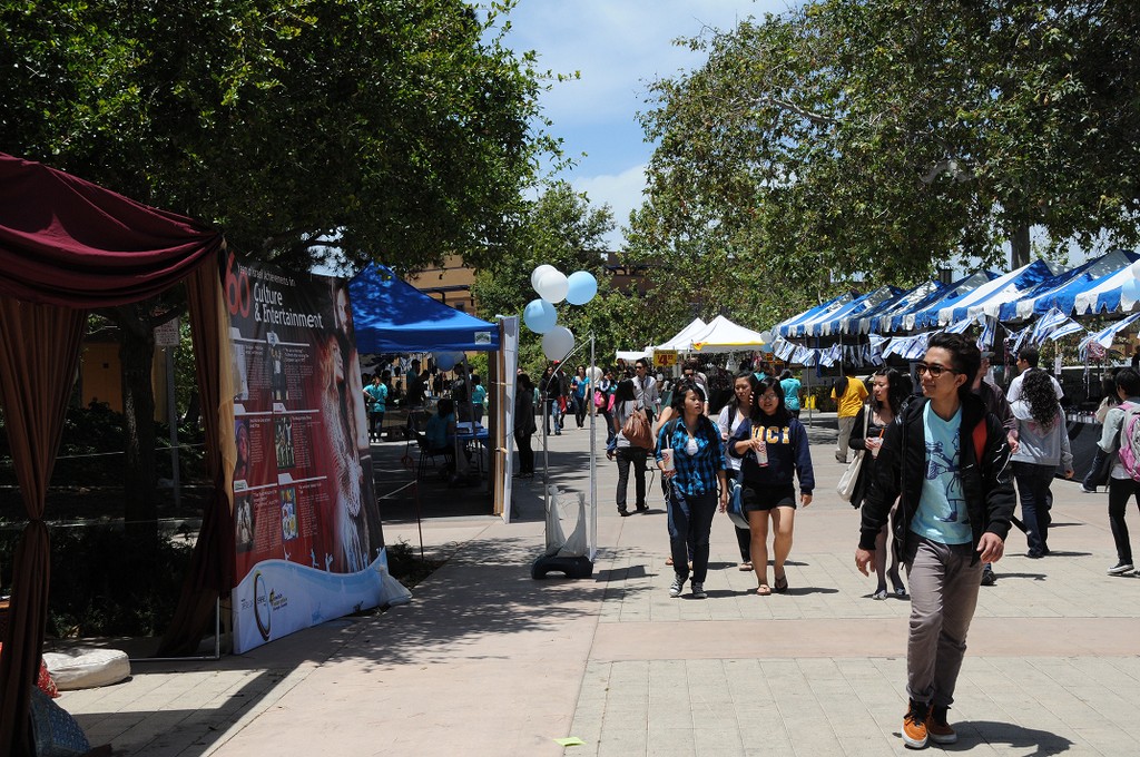 Students walking by "iFest" displays and booths on the Ring Mall ...